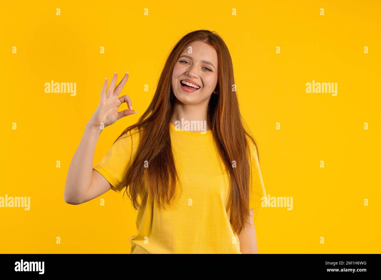 Pretty woman makes hand sign okay, ok gesture. Happy ginger girl ...