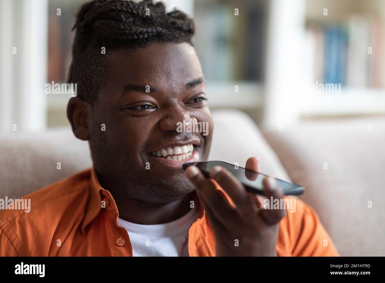 Closeup of happy black man recording voice mail on smartphone Stock ...