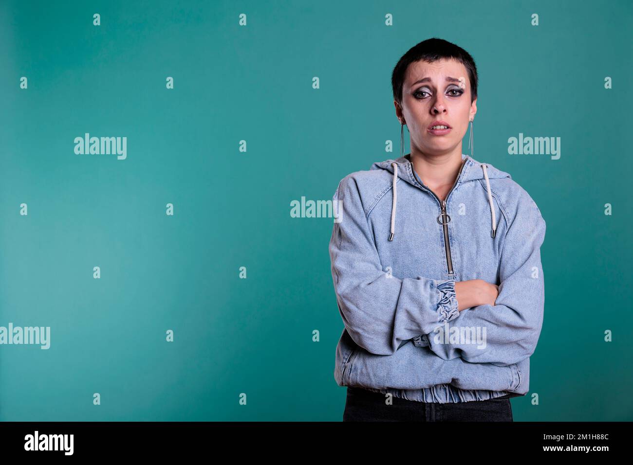 Sad upset woman crying at camera having negative displeased expression while posing in studio ...