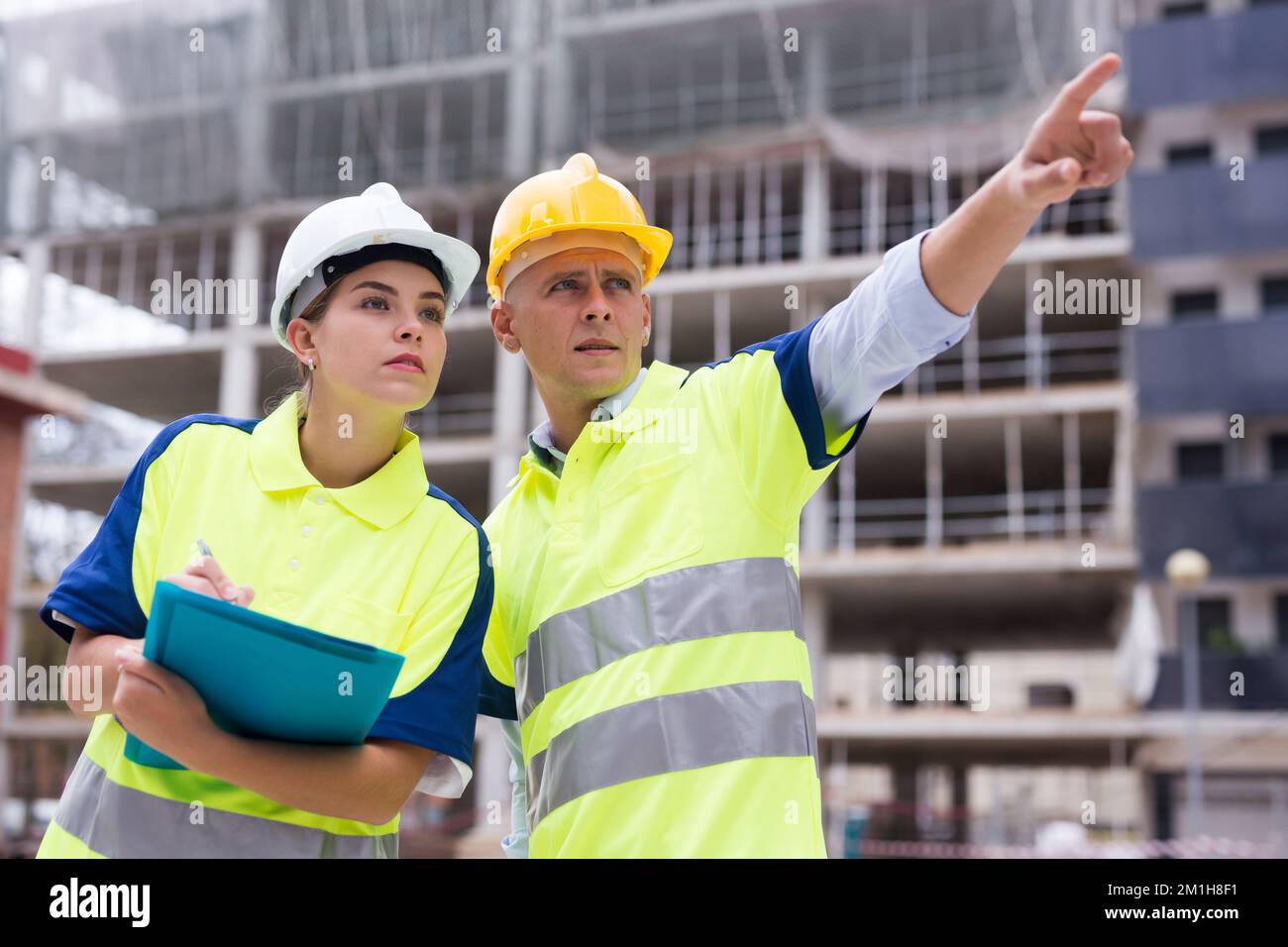 Male and female builders talking in construction site Stock Photo - Alamy