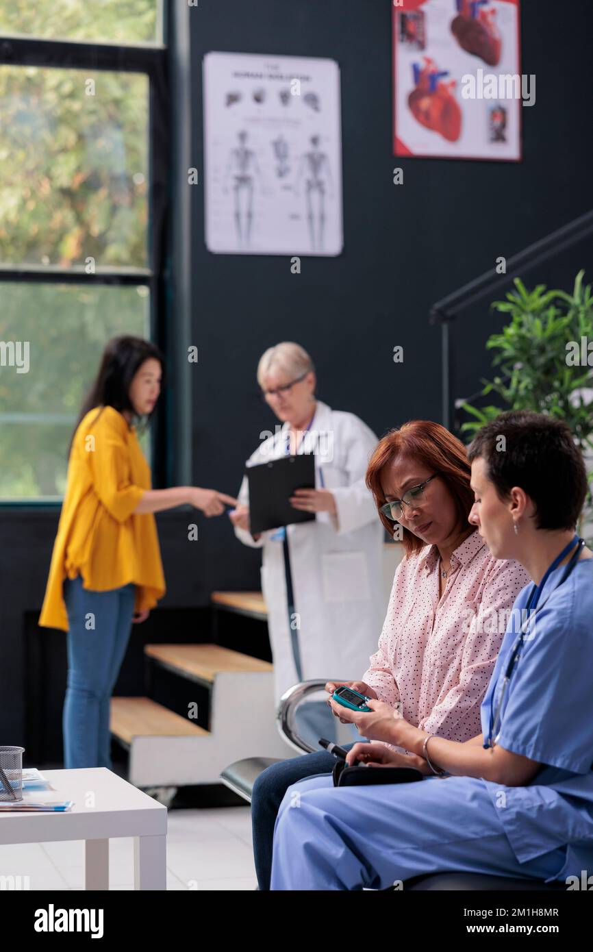 Medical assistant measuring sugar level with blood sample to do insulin ...