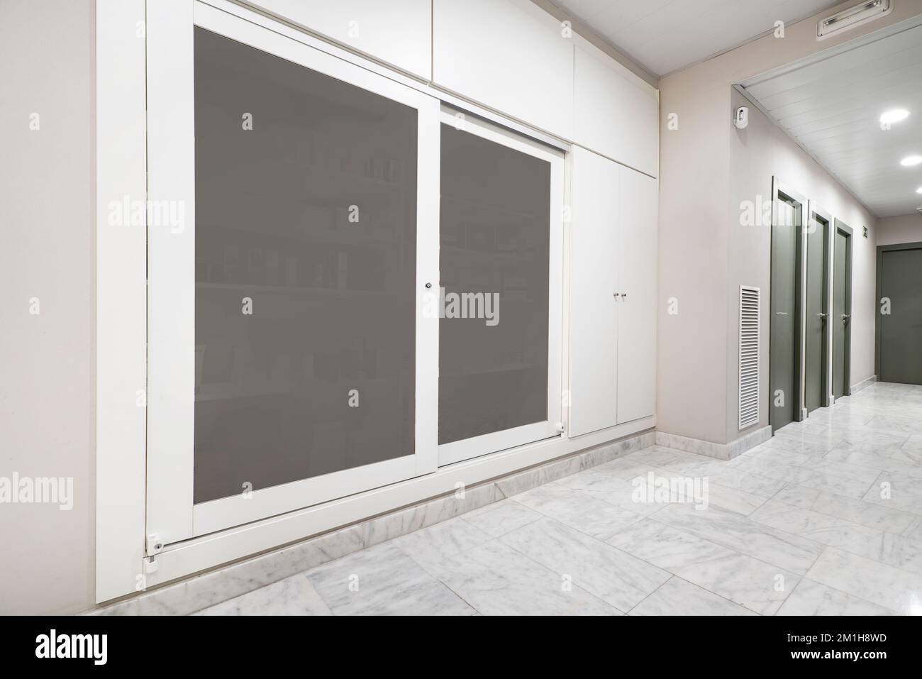 Sliding glass door wardrobe with white wood and marble floors Stock ...