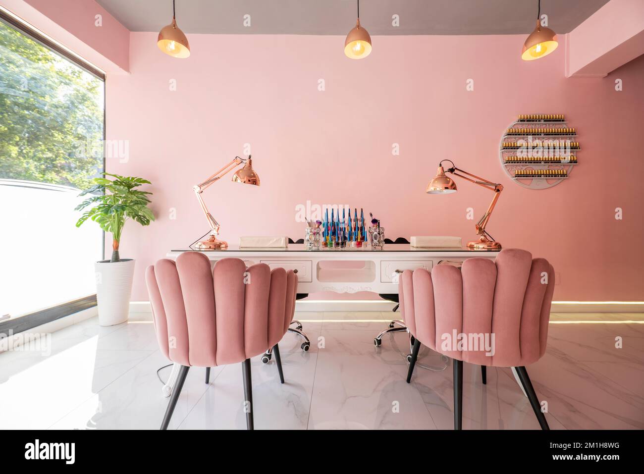 Room of a beauty salon with pink walls and pink velvet seats in a nail ...