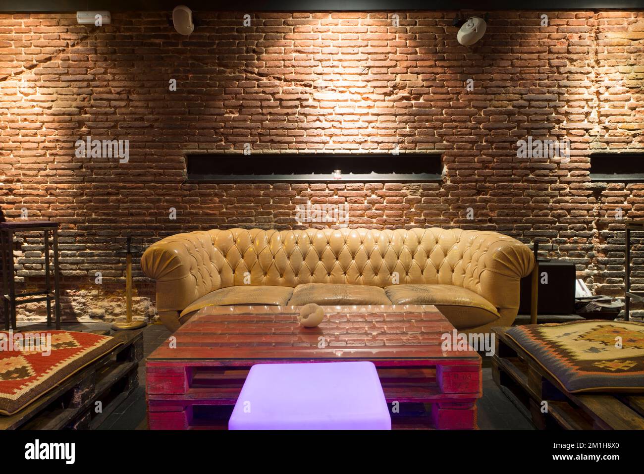 A relaxing bar space with chester style shiny cream leather upholstered ...