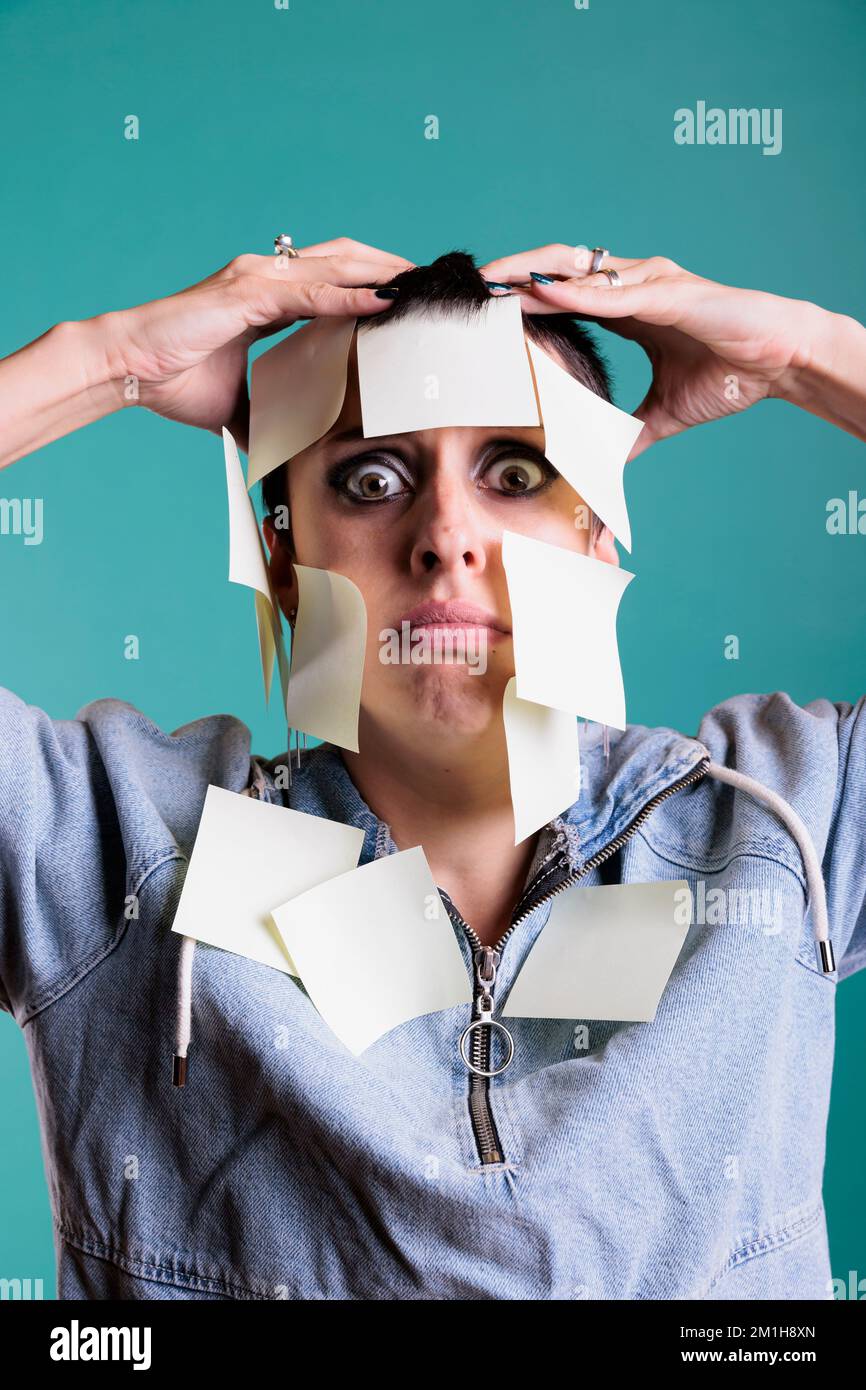 Overworked manager having colorful sicky notes all over her hair and ...