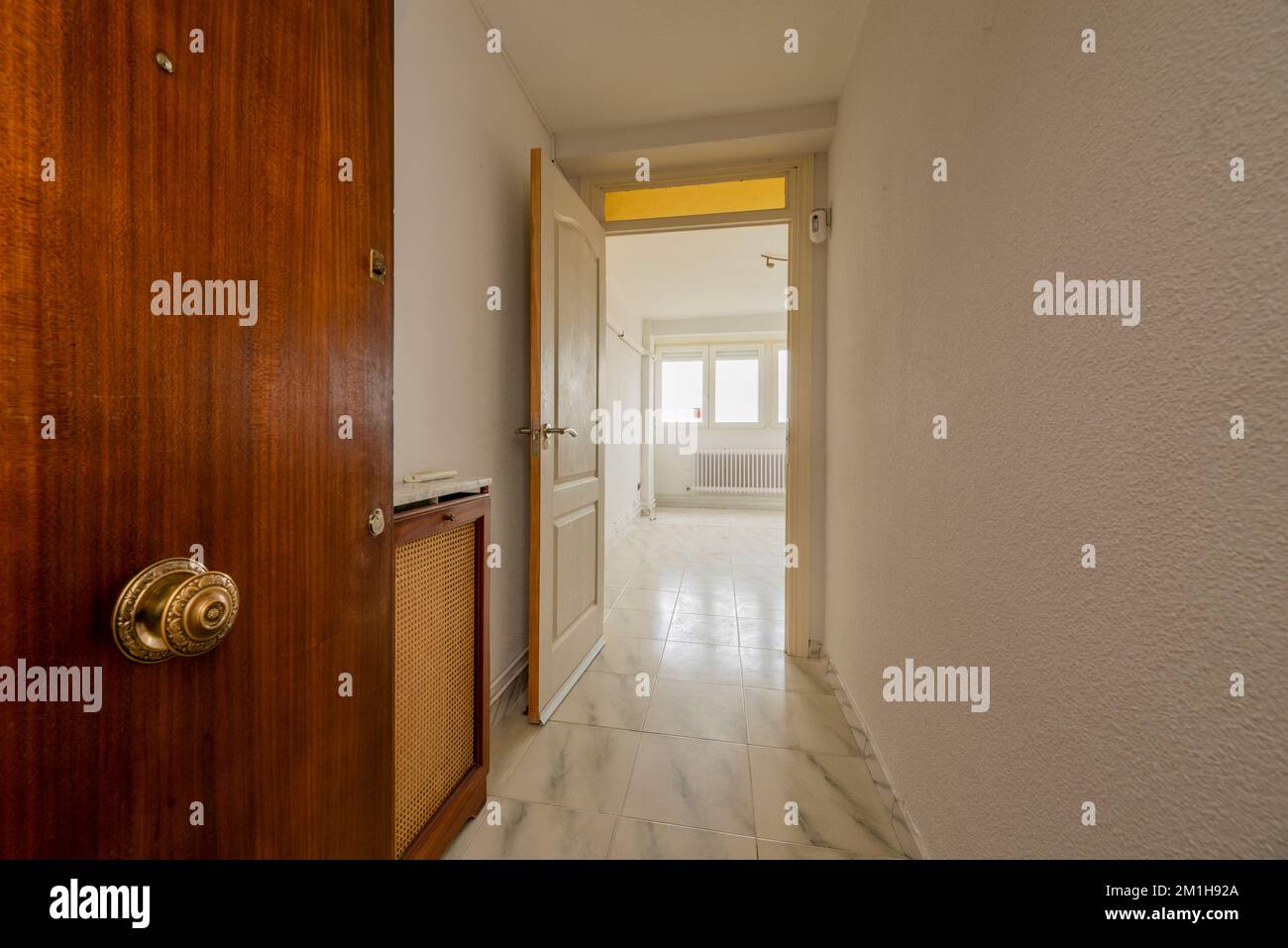 Lobby of a house with a solid wooden access door, a small corridor ...