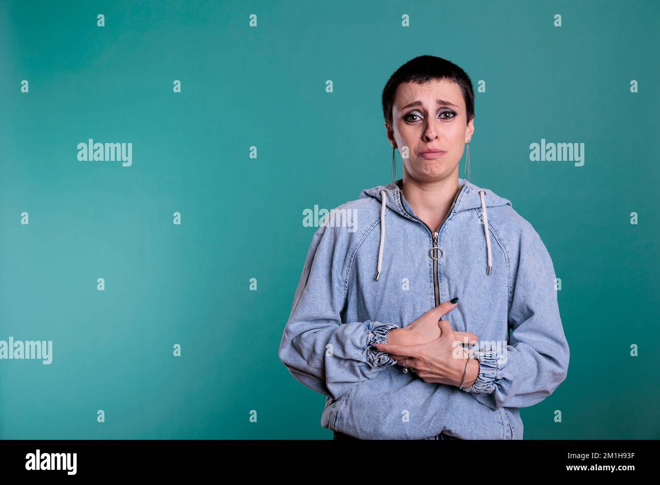 Portrait of sad unhappy woman looking at camera while crying in studio ...