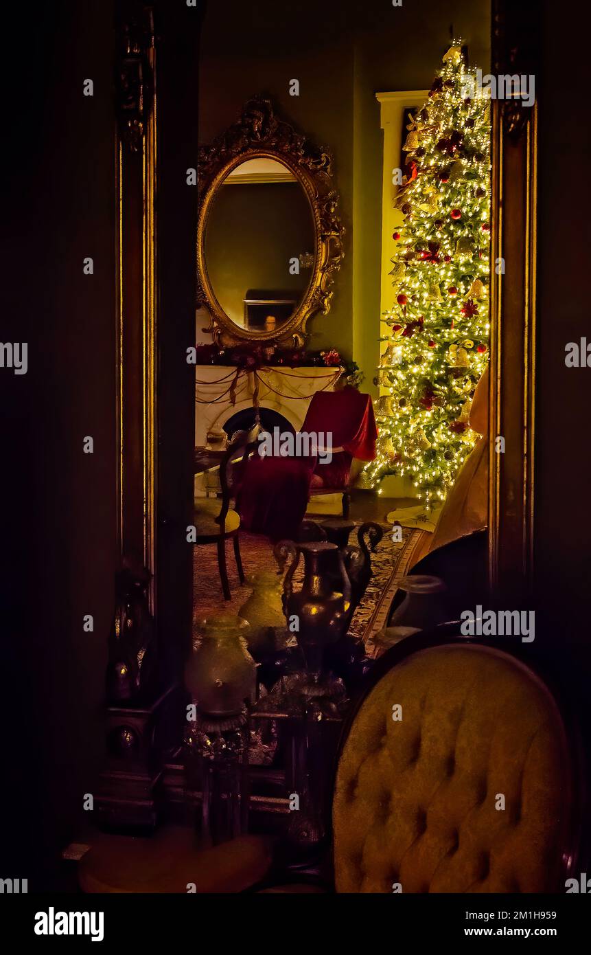 A Christmas tree is reflected in an antique mirror during Candlelight ...