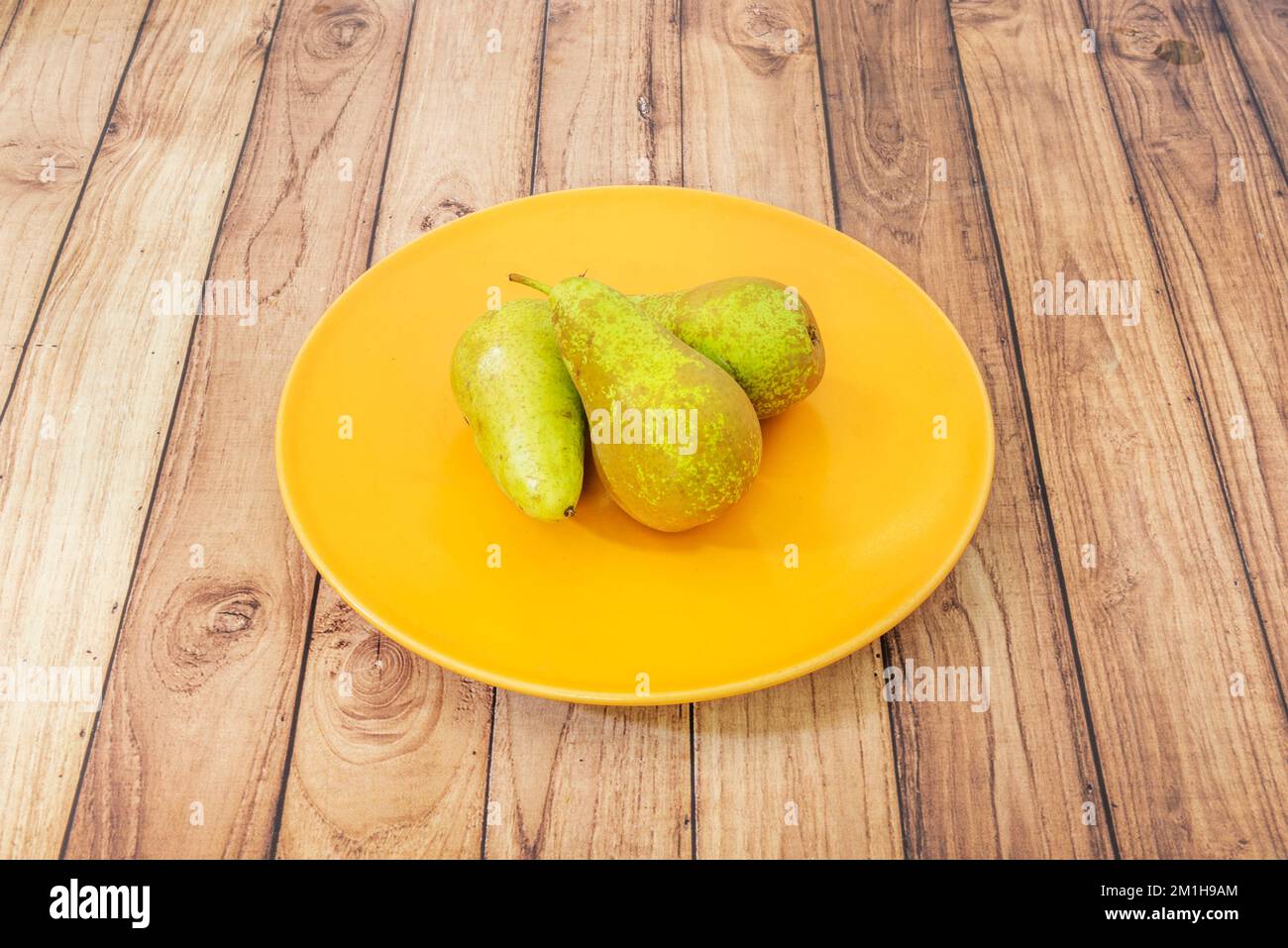 The conference pear is brown-green in color, turning pale yellow when ...