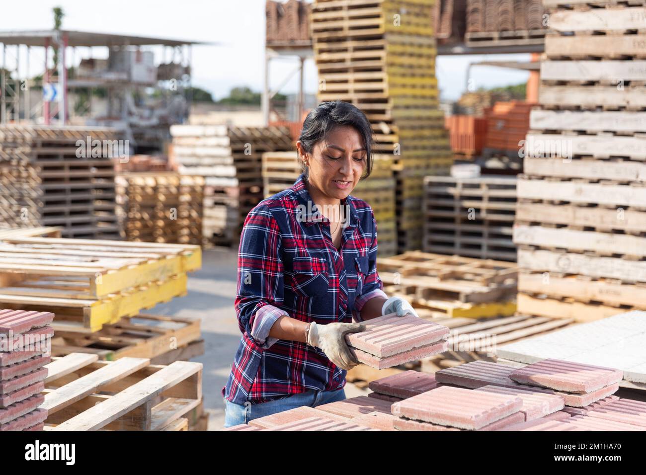 Latin american female stacking tiles on pallet Stock Photo - Alamy