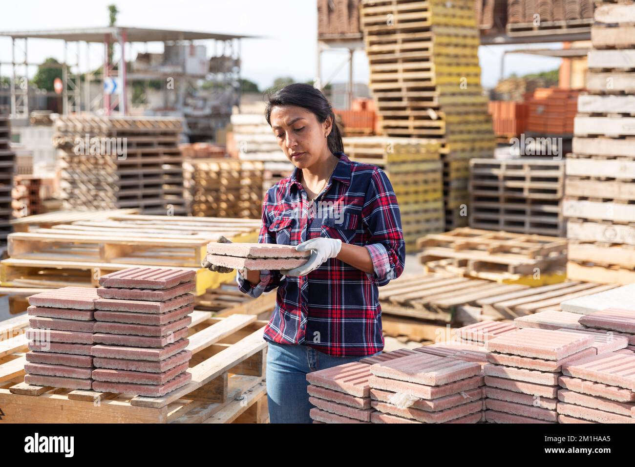 Latin american female stacking tiles on pallet Stock Photo - Alamy