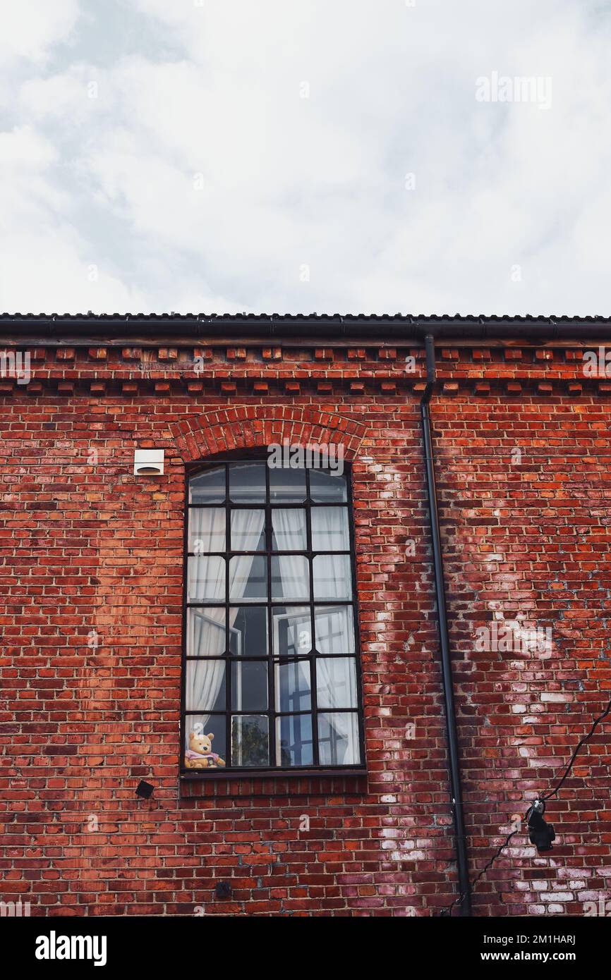 A vertical shot of a steel window on a red brick wall Stock Photo - Alamy