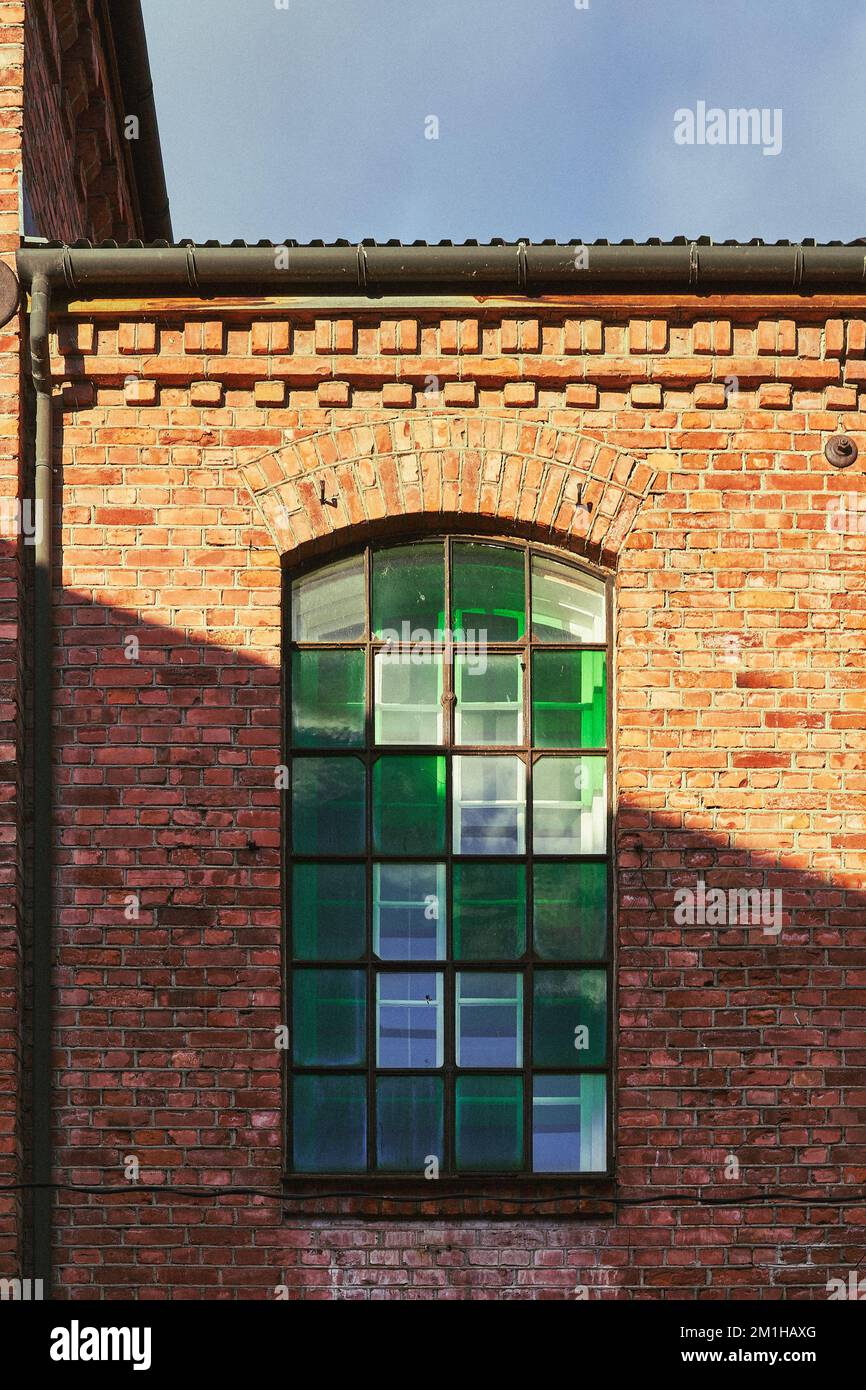 A vertical shot of a steel window on a red brick wall Stock Photo - Alamy