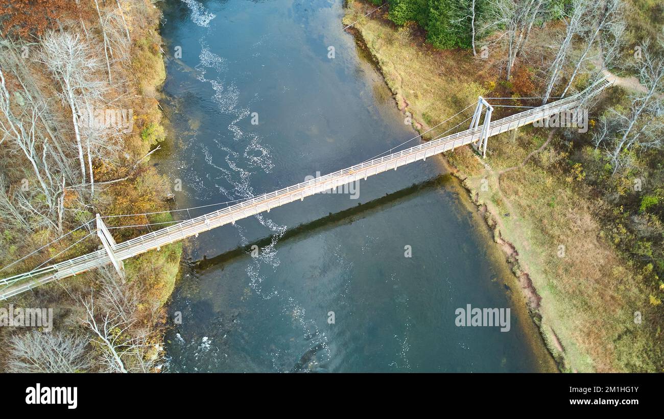 Looking down at suspension bridge going over river in late fall Stock ...