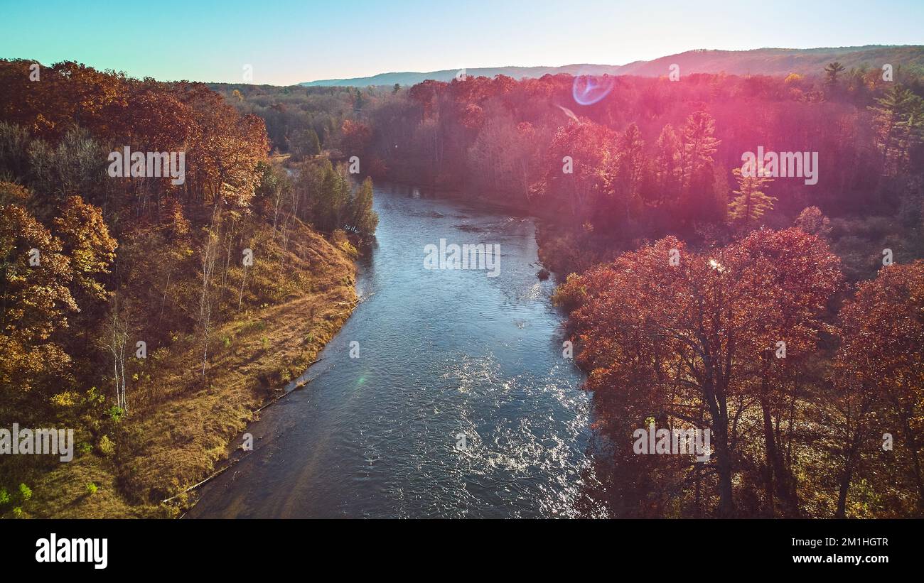Aerial solar flare over Michigan river during late fall with warm ...