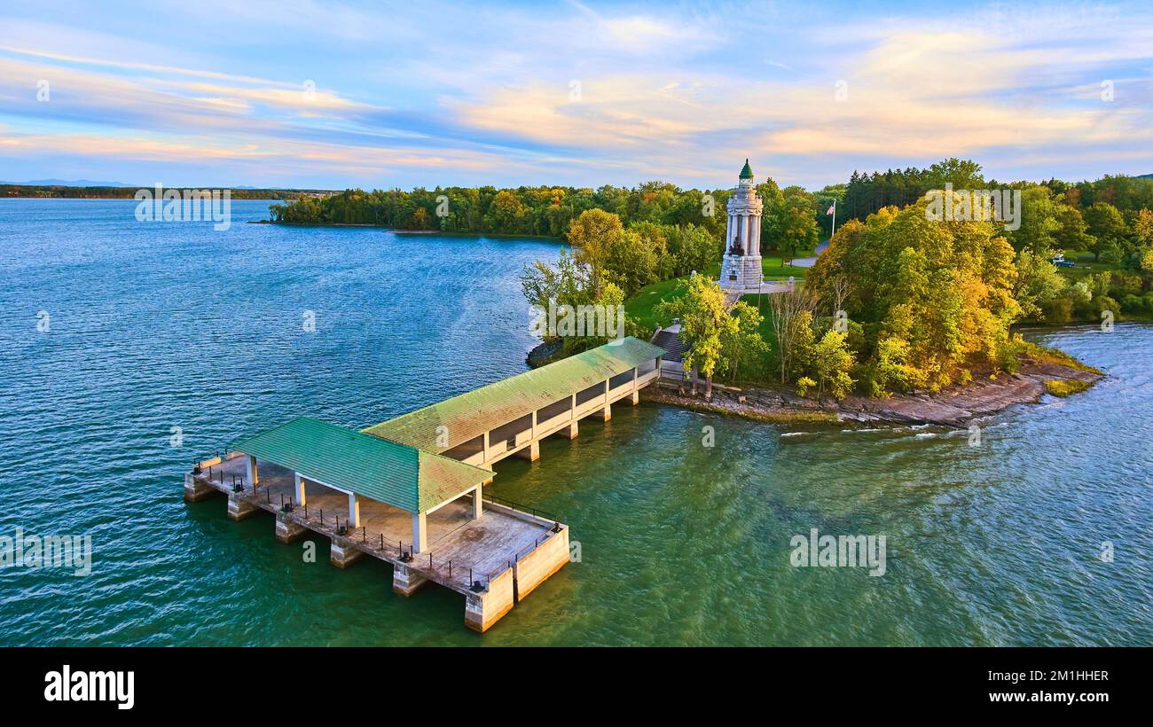 Aerial over stunning old dock and stone tower on the coast during fall ...