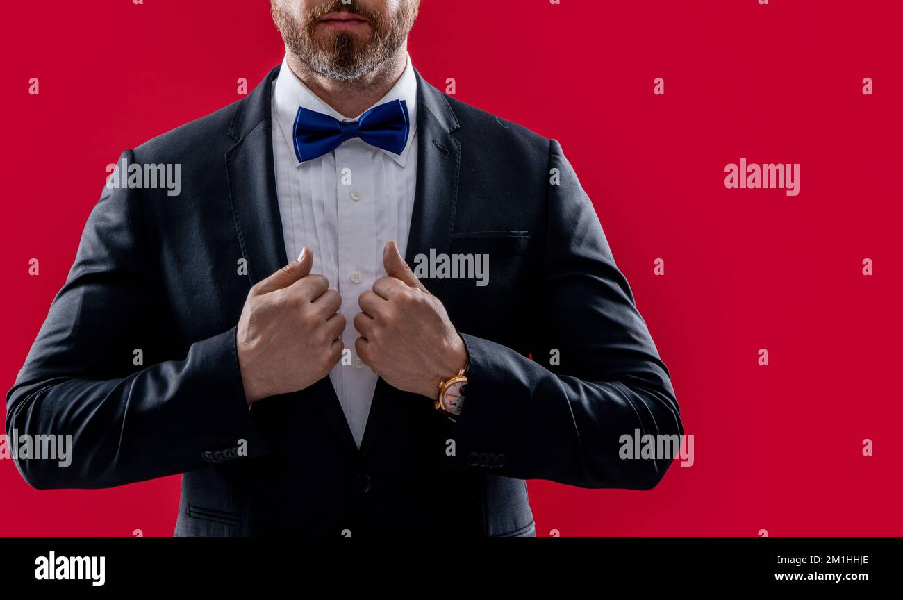 man in tux isolated on red background with copy space. tux man in ...