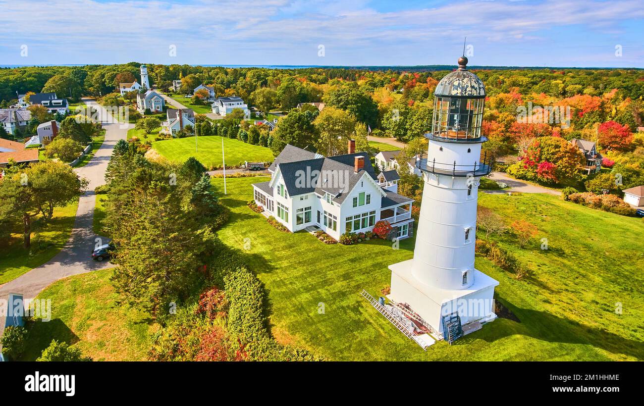 Pair of white lighthouses on hill with homes and fall foliage Stock ...