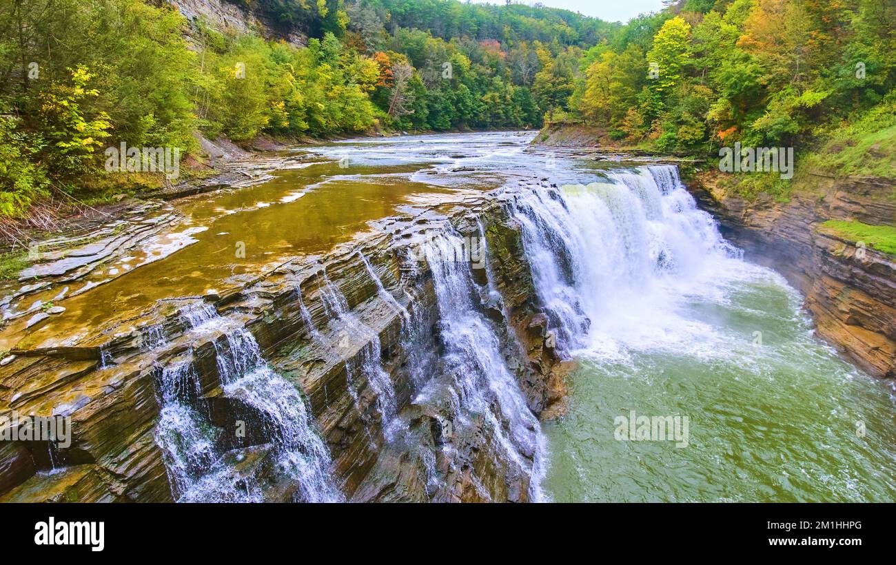 Up close with drone to beautiful waterfall eroding cliffs with colorful ...
