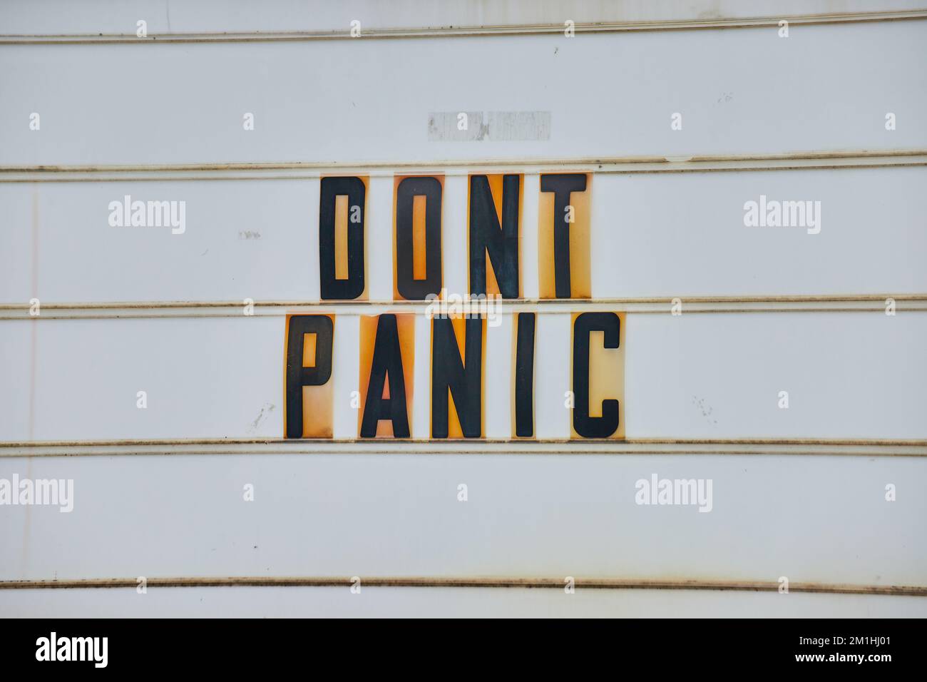 Detail of road sign all white with black capital letters DONT PANIC ...