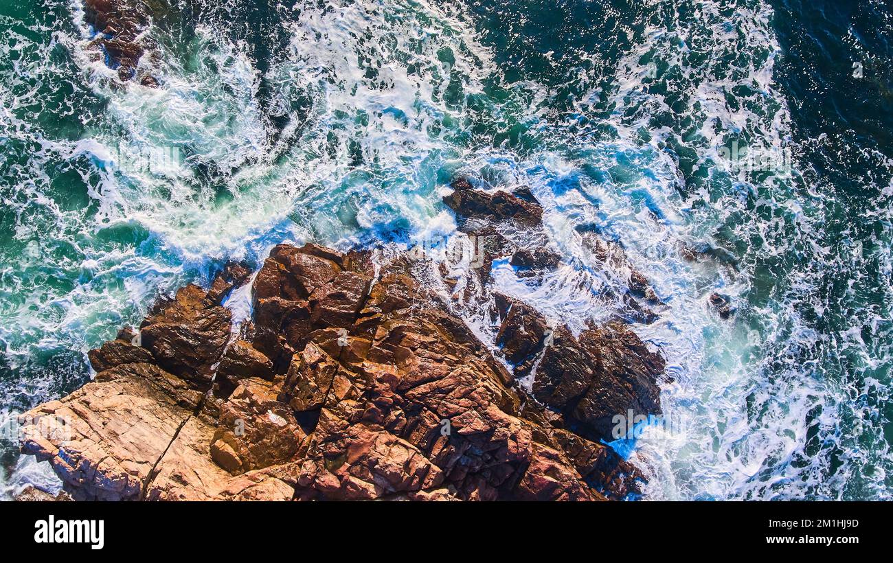 Waves crashing into rocky coasts of Maine aerial from above looking ...