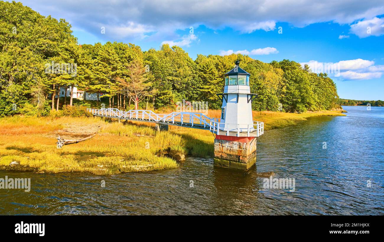 Fall foliage on coast with small lighthouse in Maine and walkway Stock ...