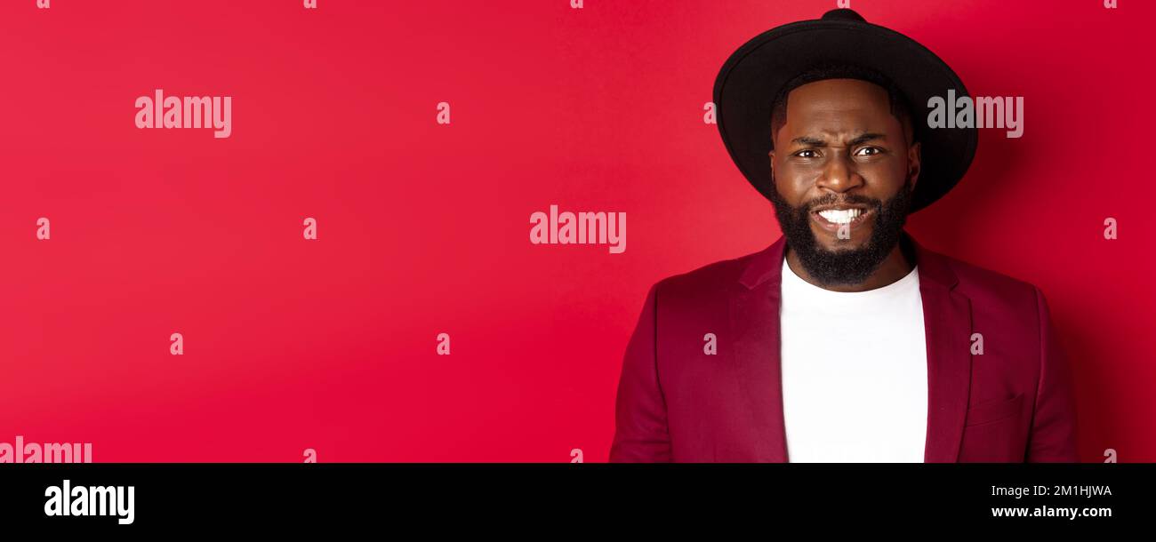 Close-up of Black man feeling uncomfortable, grimacing as watching ...