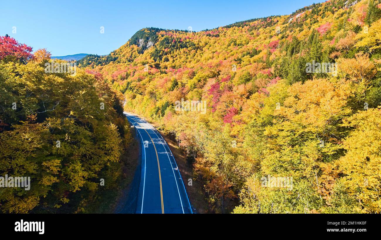 Aerial over road through New Hampshire mountains in peak fall Stock ...