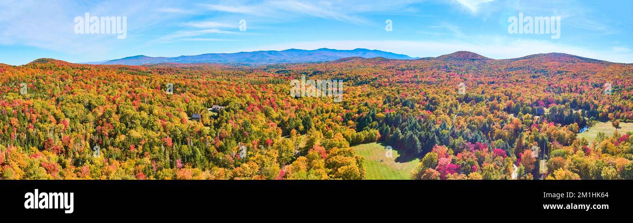 Panoramic aerial over peak fall forest mountains in Vermont with blue ...