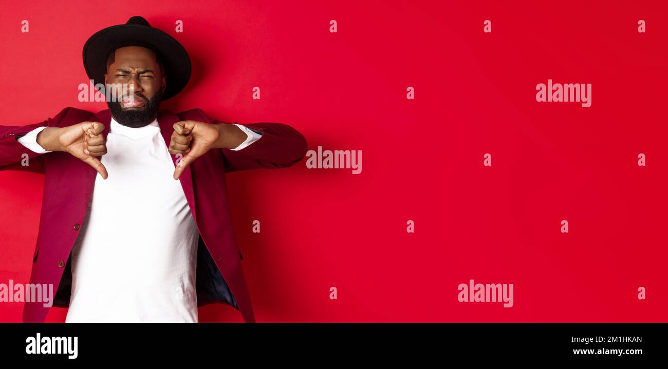 Disappointed Black man leave negative feedback, showing thumb down and ...