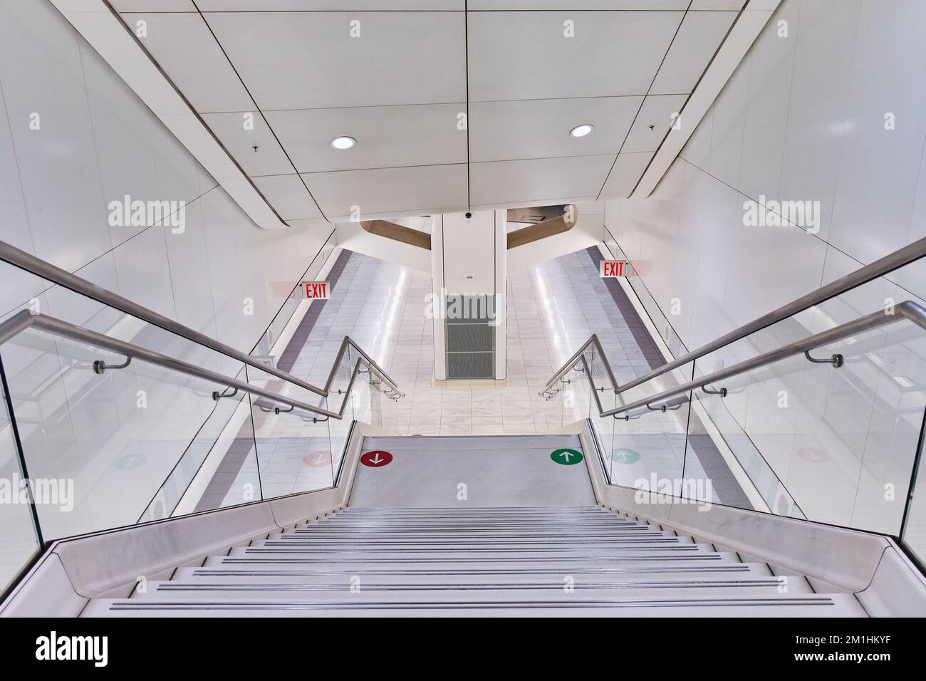 Modern clean white subway station stairs leading down to tracks with ...