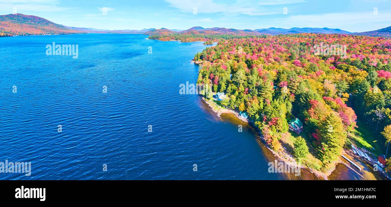 Aerial panorama over blue lake in fall with endless forest and ...
