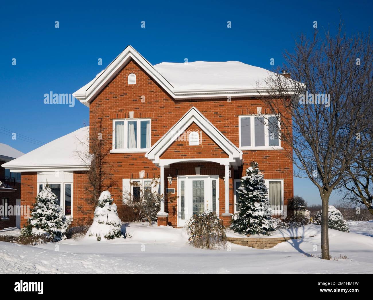 Contemporary red brick with white trim two story home in winter Stock ...