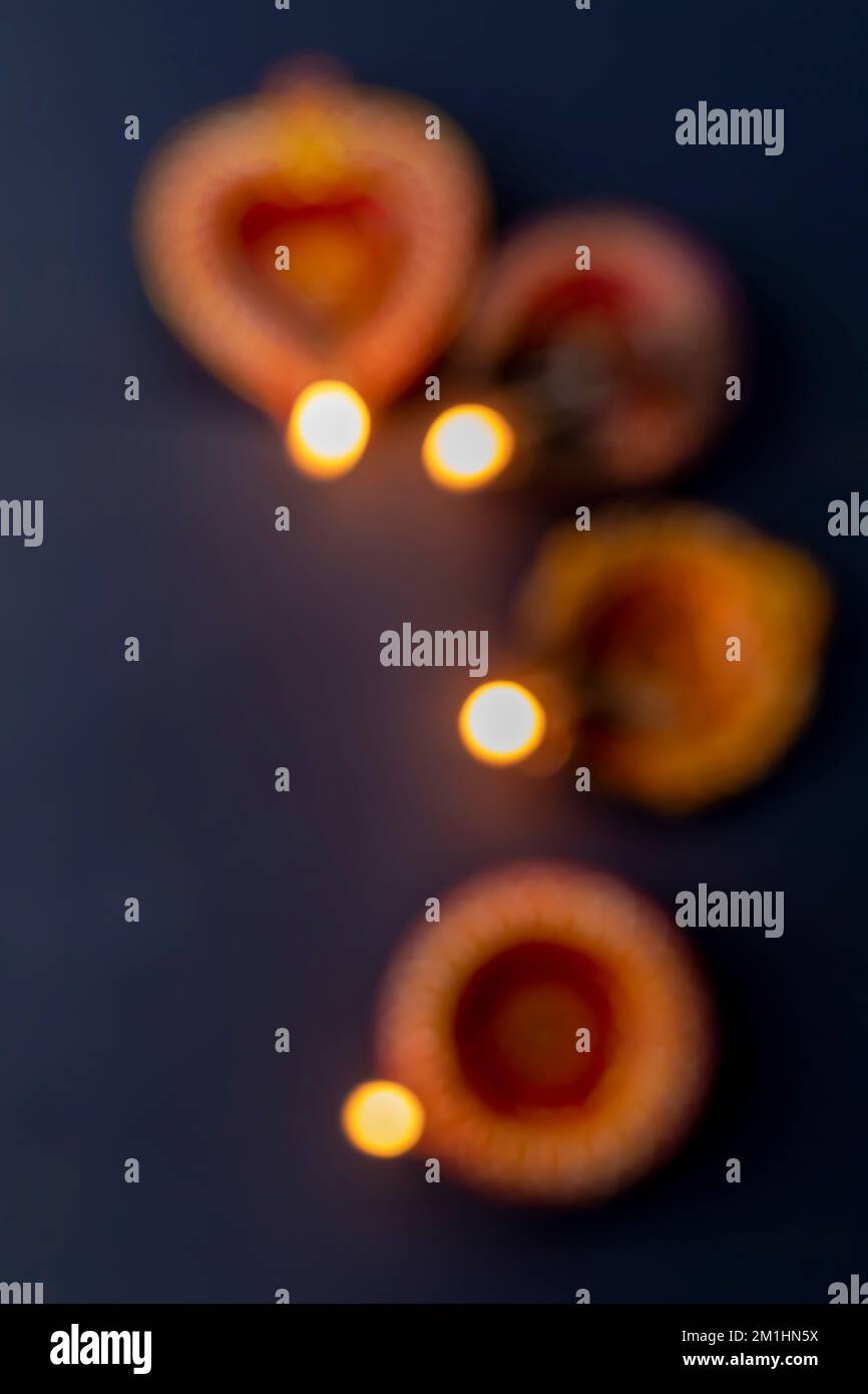 Happy Diwali. Dim clay diya lamps lit against a black background. Hindu ...