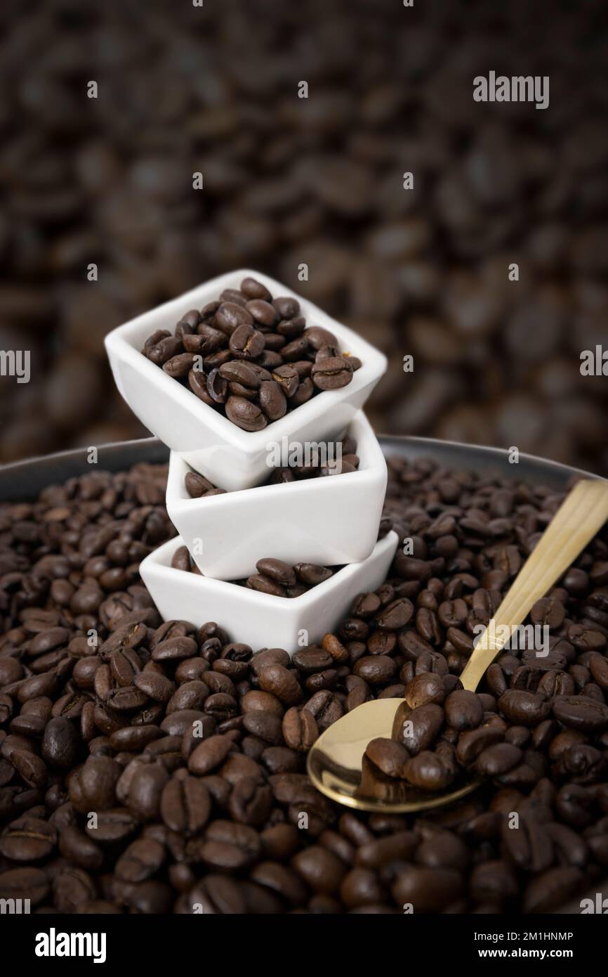 Coffee beans on a plate on a serving board with a gold teaspoon Stock ...