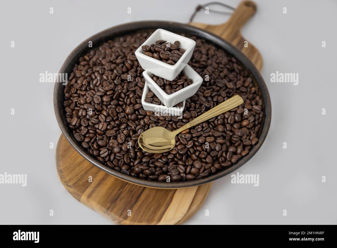 Coffee beans stacked in three white dishes with a gold tea spoon Stock ...