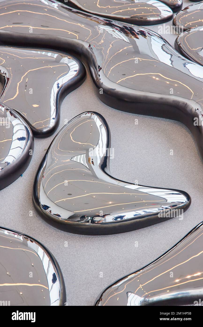 Art exhibit detail of melting metal reflecting shapes on ground Stock ...