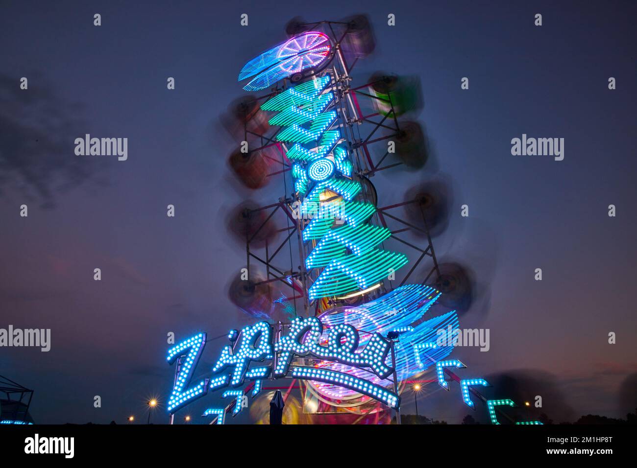 Zipper carnival ride with blurred lights during dusk at county fair ...