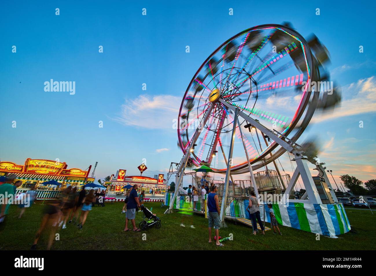 Carnival county fair with ferris wheel attraction at dusk Stock Photo ...