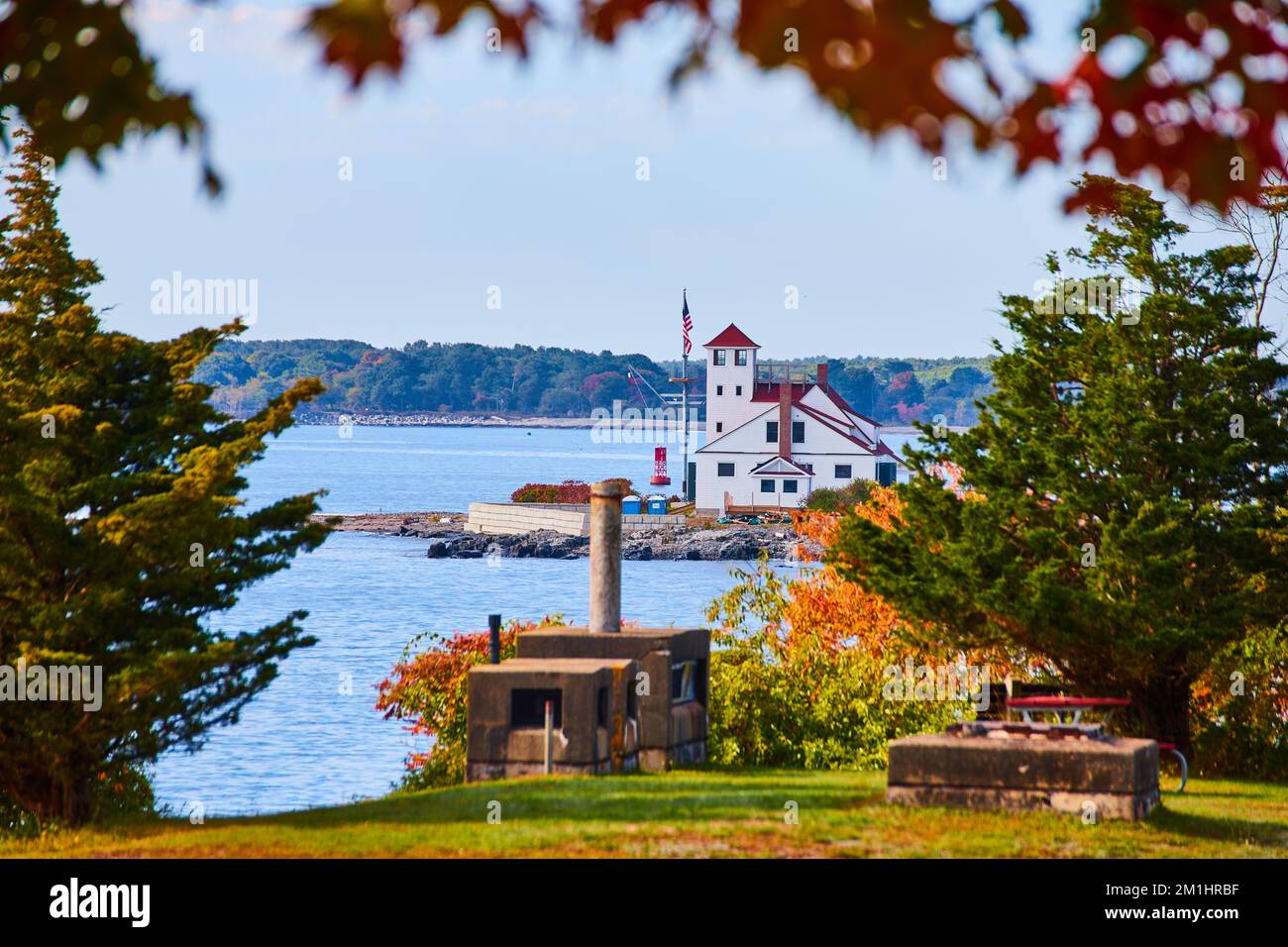 View through forest trees of Maine island housing white home for ...