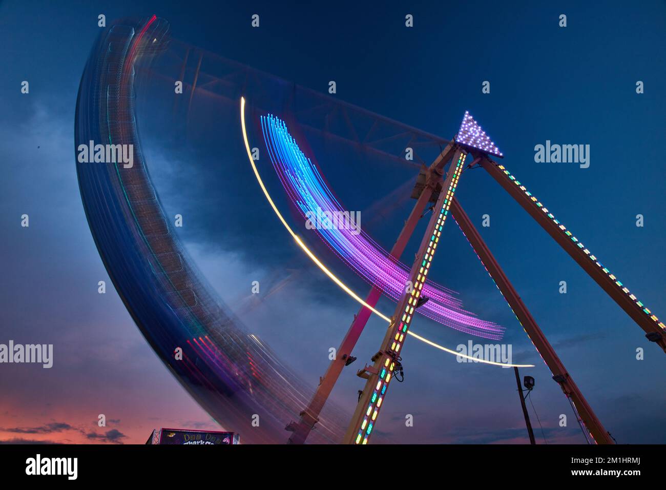 Blurred carnival ride swinging during dusk Stock Photo - Alamy