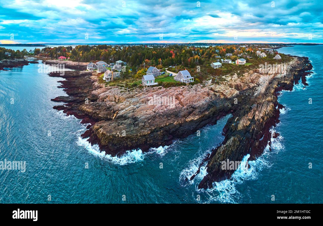 Stunning aerial over rocky coasts of Maine on the ocean with houses ...