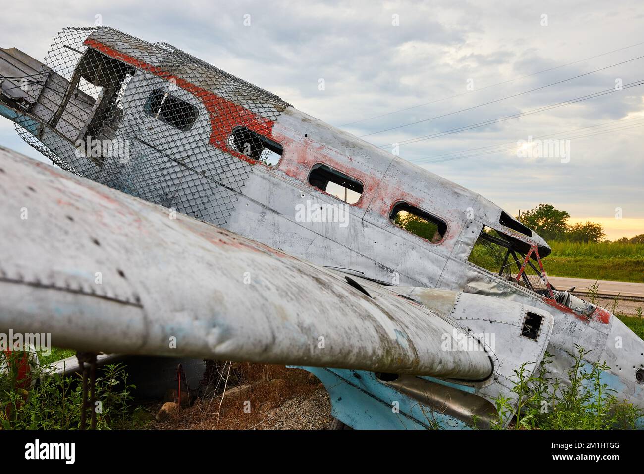 View from side of crashed airplane setting in field with dusk light ...