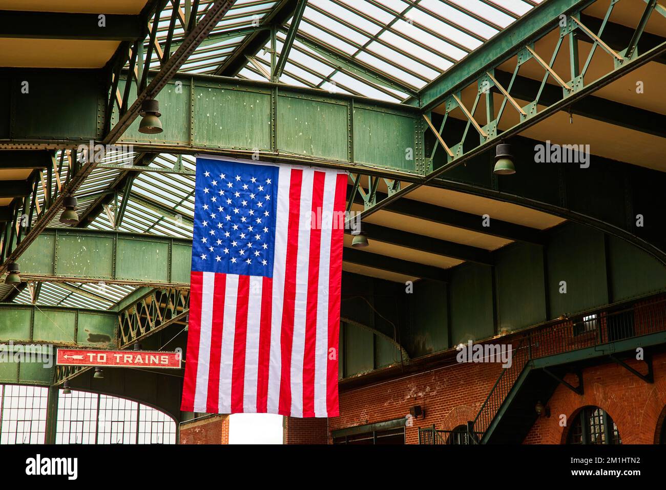American flag hangs from steel open ceiling in train station of New ...