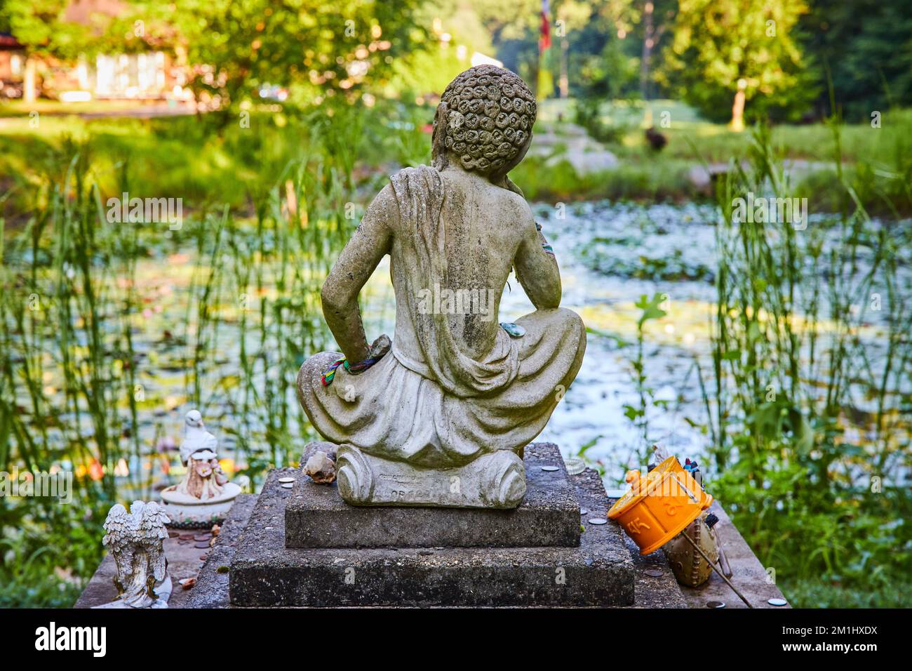 A peaceful lily pond with Tibetan Mongolian Buddhist stone statue ...