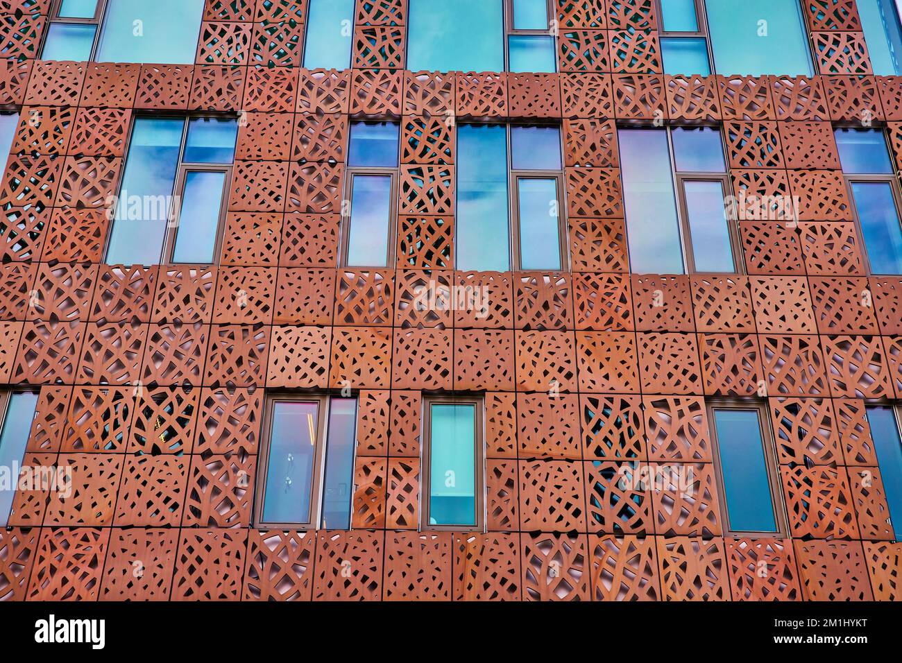 Metal cutout shapes cover exterior building broken up by windows Stock ...