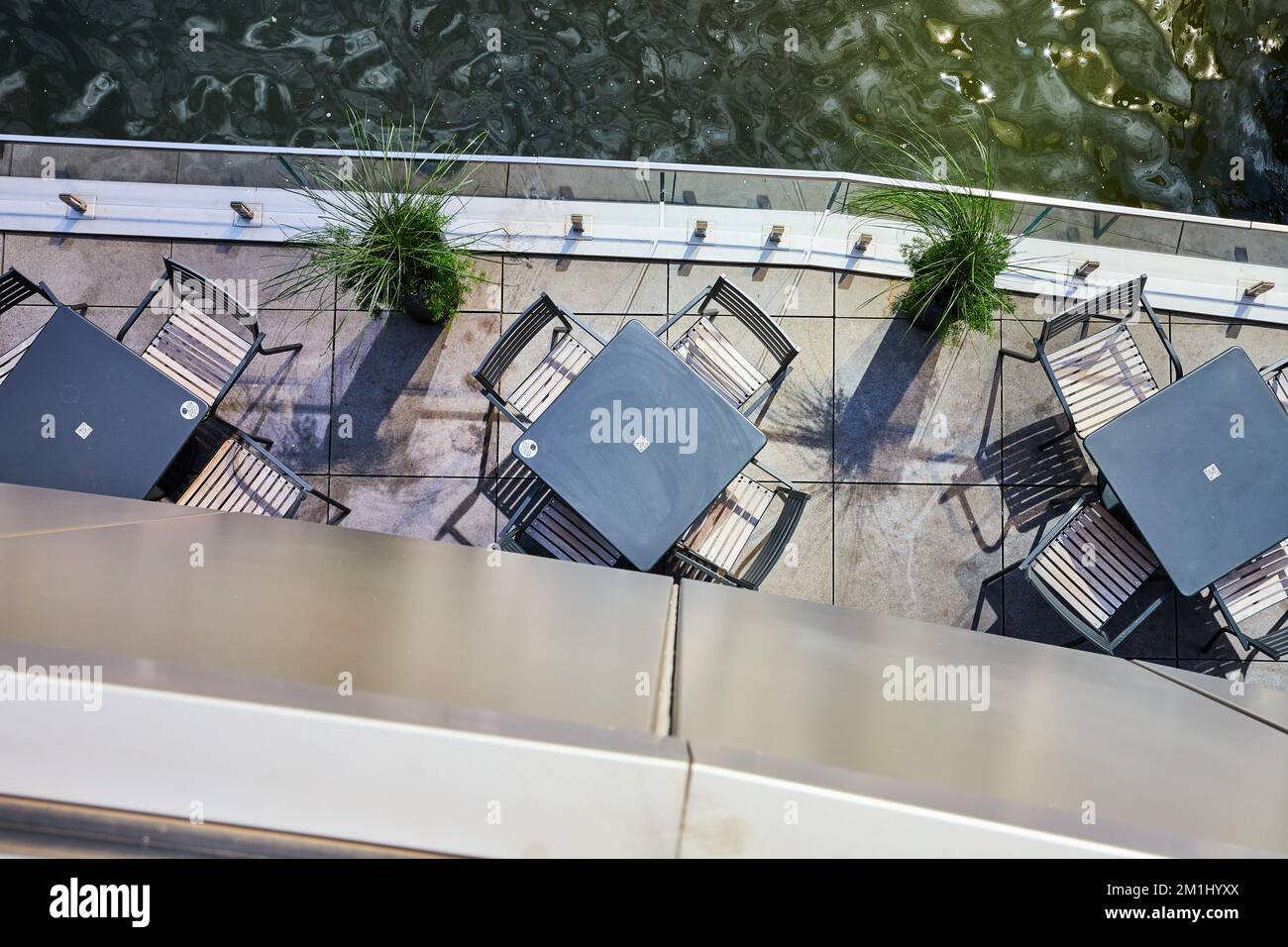 Looking down on dining patio tables next to water Stock Photo - Alamy