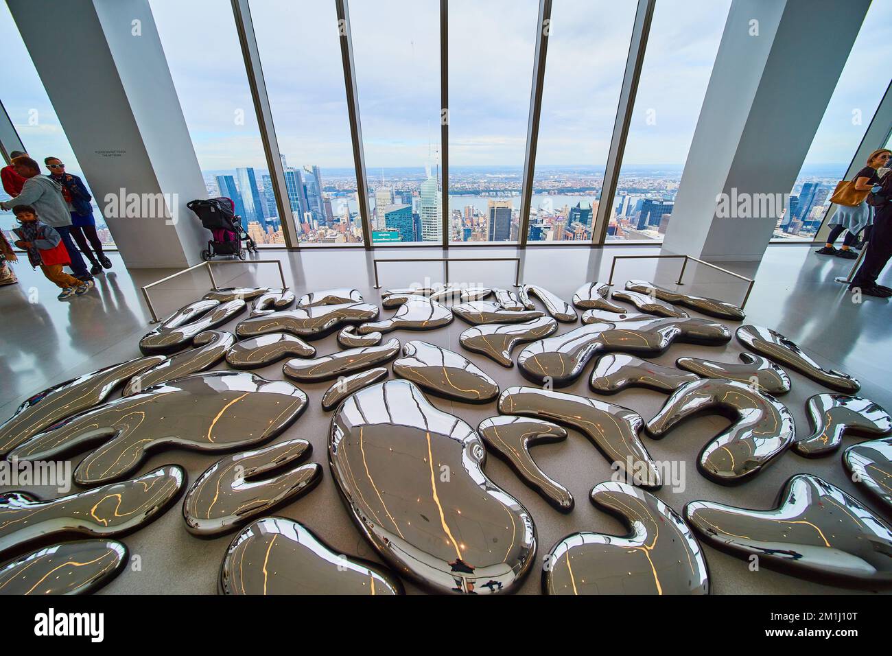 High up skyscraper overlooking city with art exhibit melting reflective ...