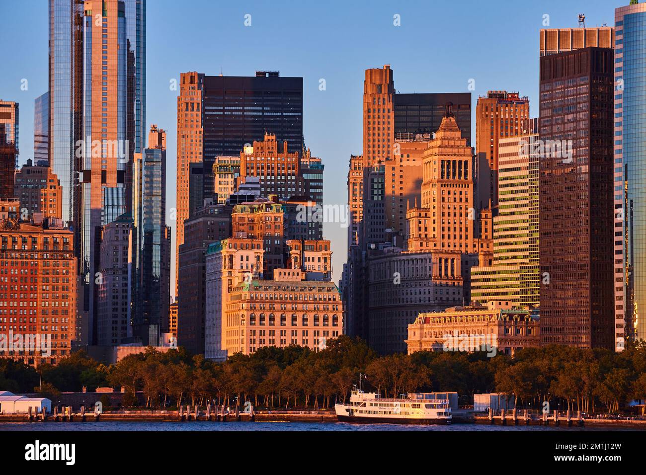 Golden light over New York City skyscrapers in detail from off coast of ...