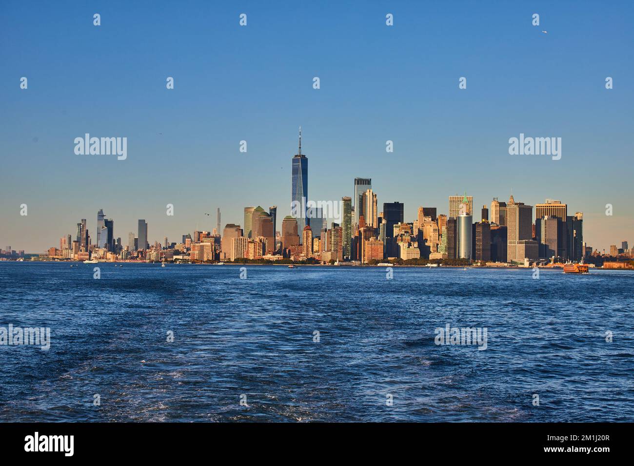 Stunning southern Manhattan island from ferry with soft golden light ...
